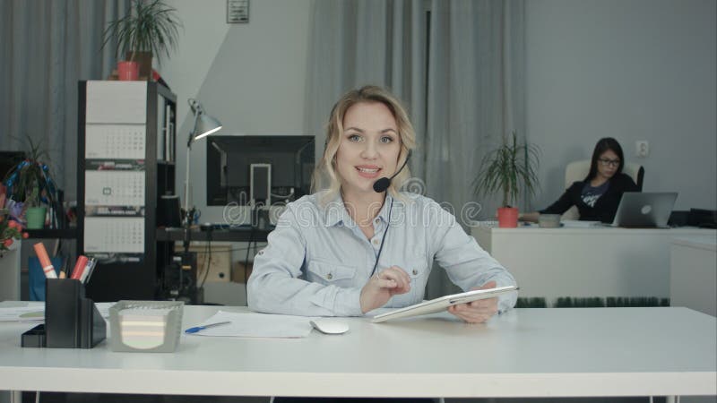 Smiling Call Center Agent Using Tablet and Talking To the Camera Stock ...