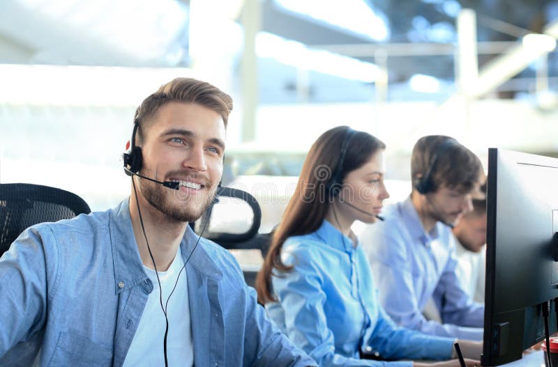 Smiling Call Center Employees Sitting in Line with Their Headset Stock ...