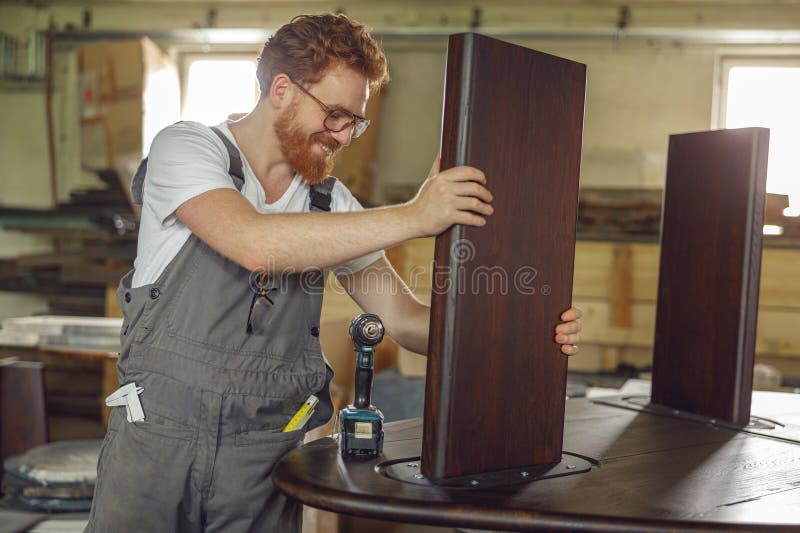 Smiling Carpenter Fixing Table with Electric Drill Standing in ...