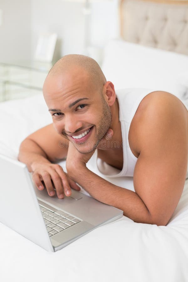 Smiling Casual Bald Man Using Laptop in Bed Stock Photo - Image of ...