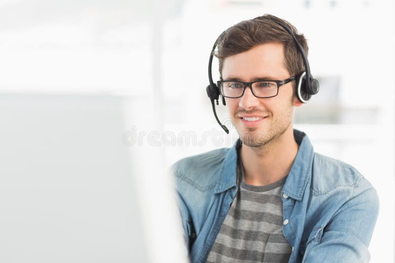 Smiling Casual Young Man with Headset Using Computer Stock Photo ...