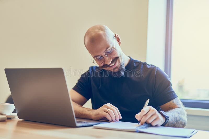 Smiling Caucasian Bald Man Manager Using Laptop while Writing Notes in ...