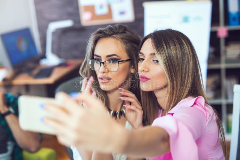 Smiling Cheerful Business Women Taking A Selfie In The Office Stock