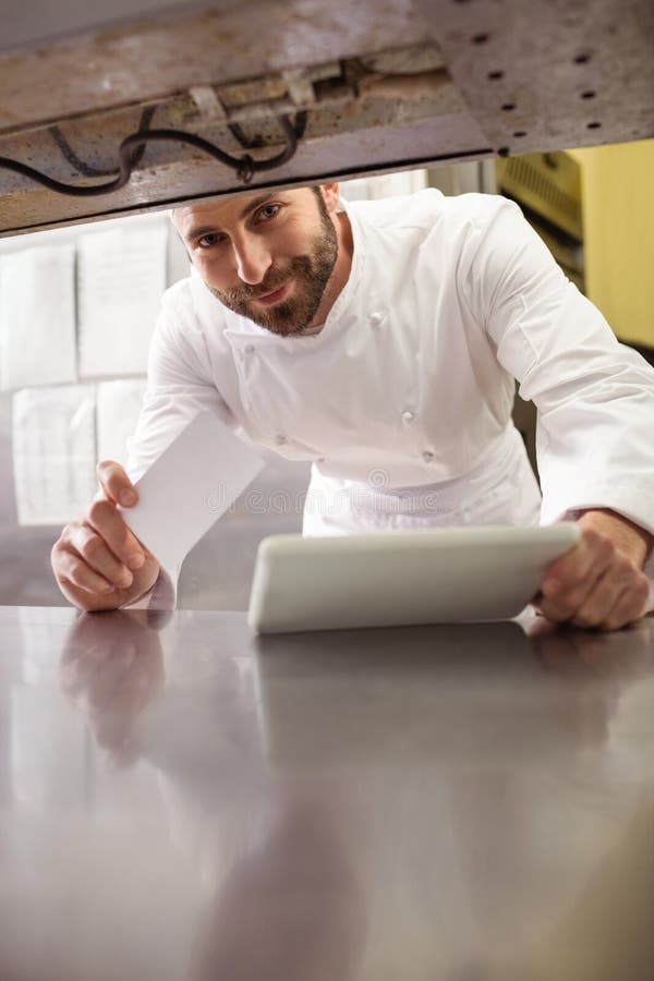 Smiling Chef Holding Order Note and Digital Tablet in Kitchen Counter ...