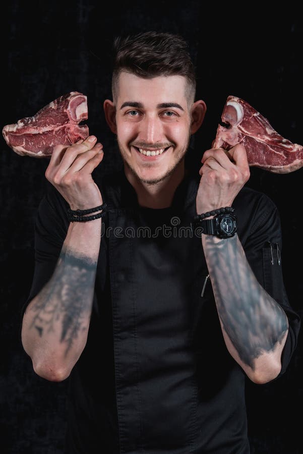 Smiling Chef Plays with Raw Meat Steaks. Close-up in the Kitchen Stock ...