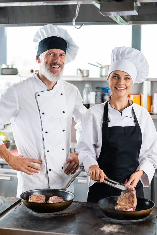 Smiling Chefs in Uniform Looking at Stock Photo - Image of roast, meat ...