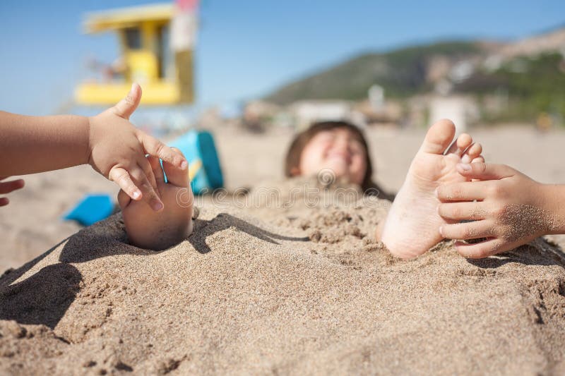 Smiling Child Covered in Sand on the Beach, Hands Tickling Siblings ...