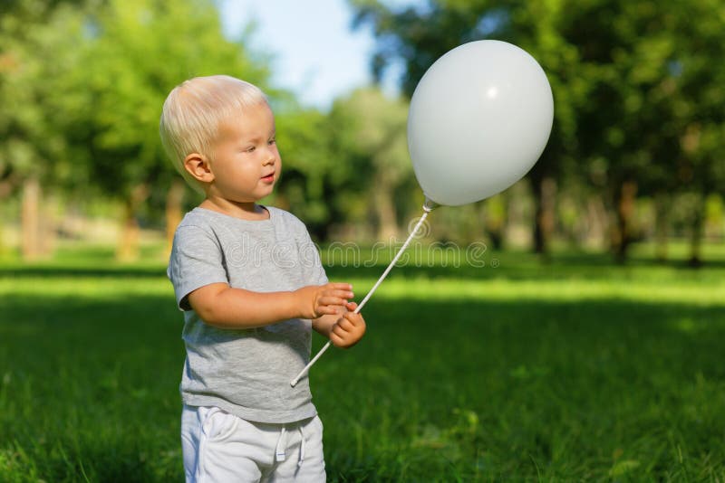 Smiling Child Holding a White Balloon in the Hand Stock Image - Image ...