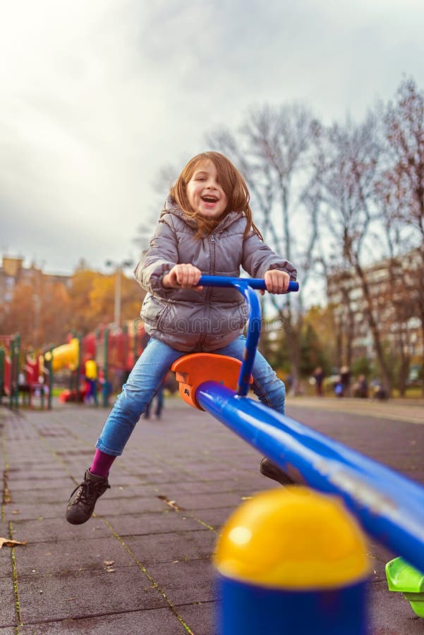 Smiling Child on Seesaw on the Playground in the Park Stock Photo ...