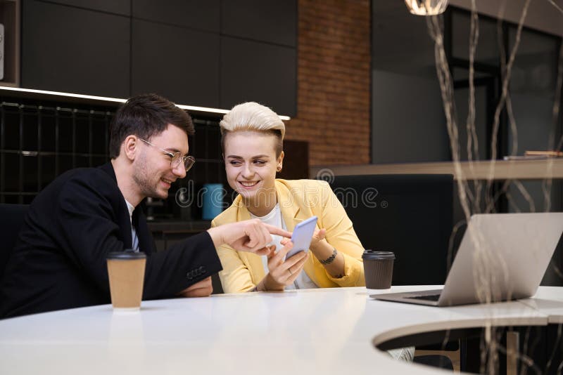 Smiling Colleagues is Looking at Smartphone Display Stock Photo - Image ...