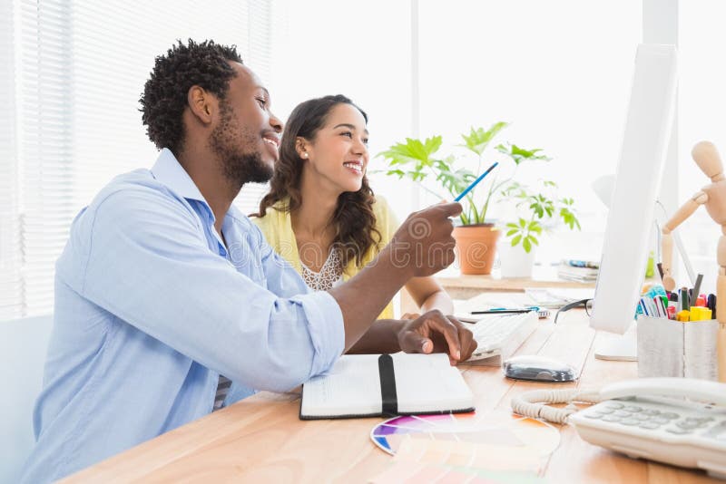 Smiling Colleagues Speaking Together at Desk Stock Photo - Image of ...