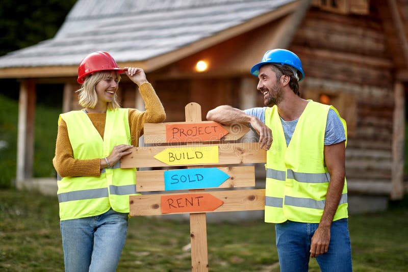 Smiling Construction Couple with Wooden Board.wooden House Structure ...