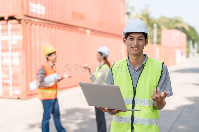 Smiling Construction Engineer Holding a Laptop while Coordinating with ...