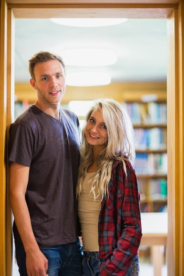 Smiling Couple Against Blurred Bookshelf in Library Stock Image - Image ...
