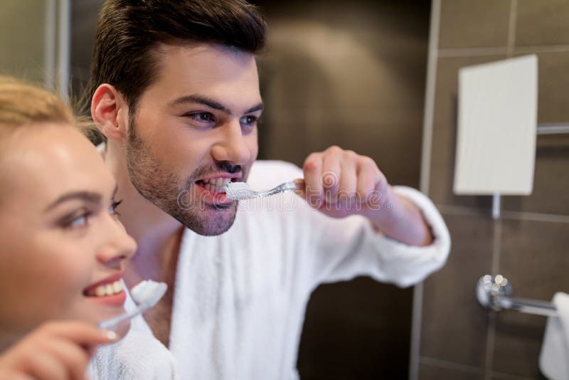 Smiling Couple Brushing Teeth and Looking Stock Photo - Image of male ...