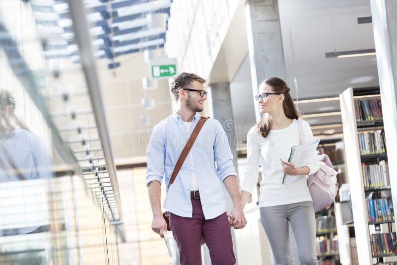 Smiling Couple Holding Hands while Talking by Library at University ...