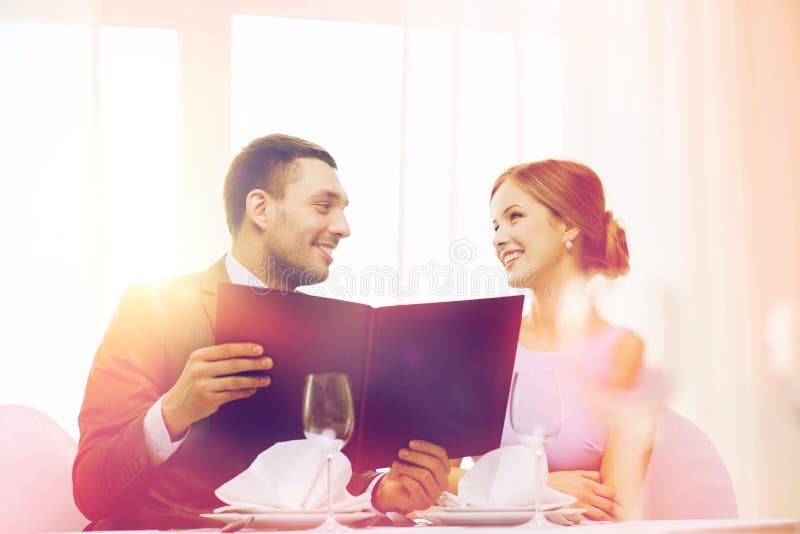 Smiling Couple with Menu at Restaurant Stock Photo - Image of happiness ...