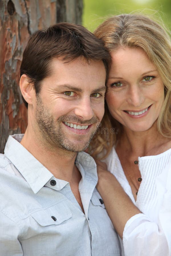 Smiling couple by tree stock image. Image of people, outside - 23859141