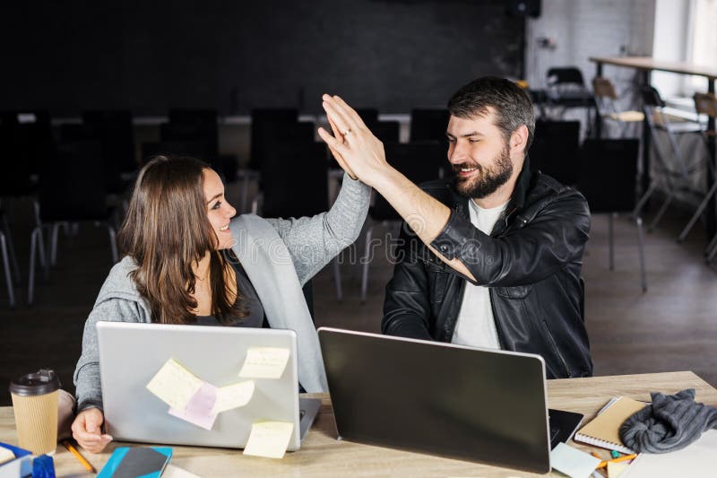 Smiling Couple Using Laptops and Giving High Five Stock Photo - Image ...