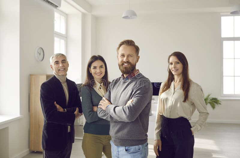Smiling Coworkers Stand Looking At Camera Creating Team Shots In Office