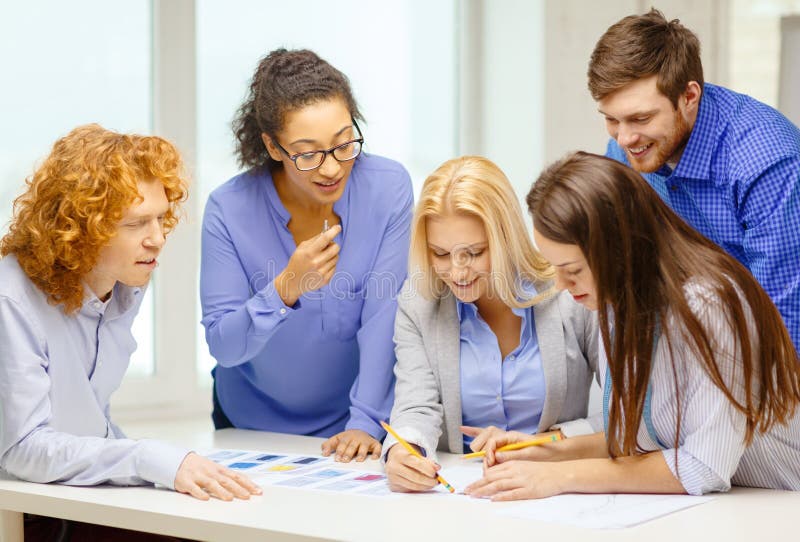 Smiling Creative Team Looking Over Clothes Designs Stock Photo - Image ...
