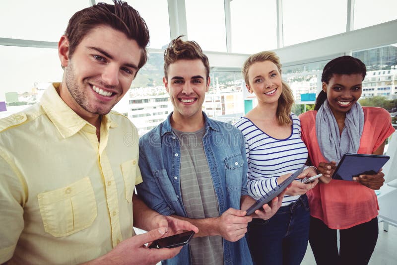 Smiling Creative Team Standing in a Line Using Technology Stock Photo ...