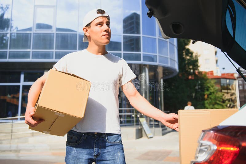 Smiling Delivery Man Holding a Paper Box Stock Photo - Image of express ...