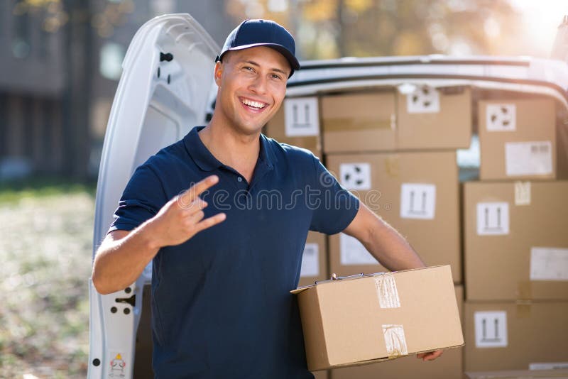 Smiling Delivery Man Standing in Front of His Van Holding a Package ...