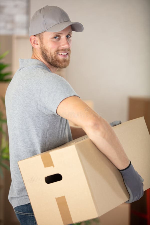 Smiling Delivery Man Standing with Parcel Stock Photo - Image of ...