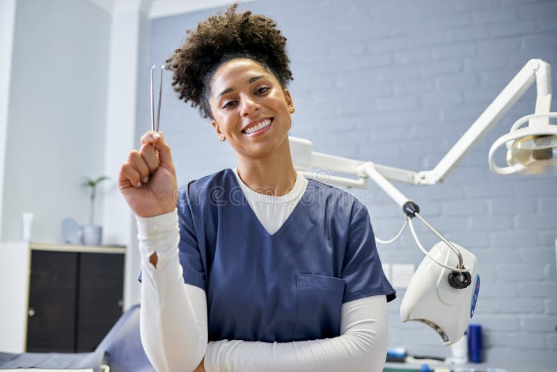 Smiling Dental Professional Holding Dental Tool in Modern Clinic ...
