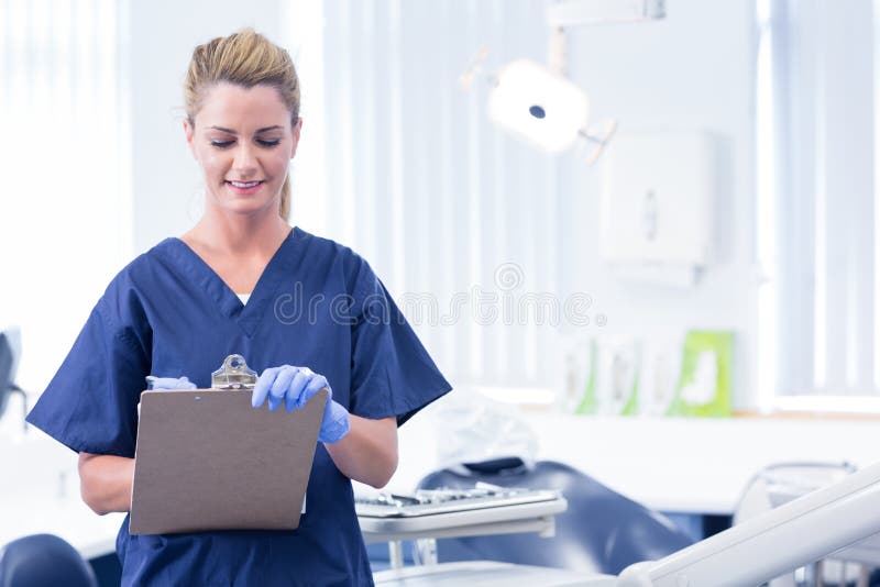 Smiling Dentist Writing in Clipboard Stock Photo - Image of dentistry ...