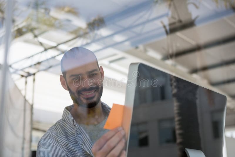 Smiling Designer Using Computer Seen through Glass Stock Image - Image ...