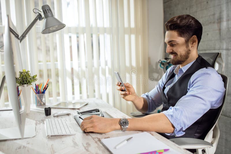 Smiling Designer Using Mobile Phone Stock Image - Image of keyboard ...