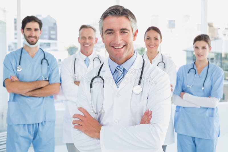 Smiling Doctor with Fellow Doctors Stock Photo - Image of mature ...