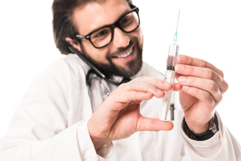 Smiling Doctor Holding Syringe and Talking by Smartphone Stock Photo ...