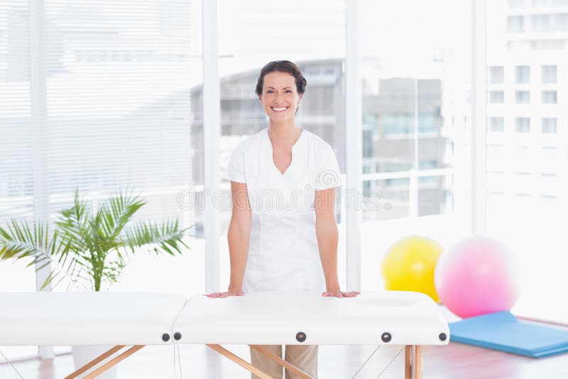 Smiling Doctor Looking at Camera Standing Behind Massage Table Stock ...