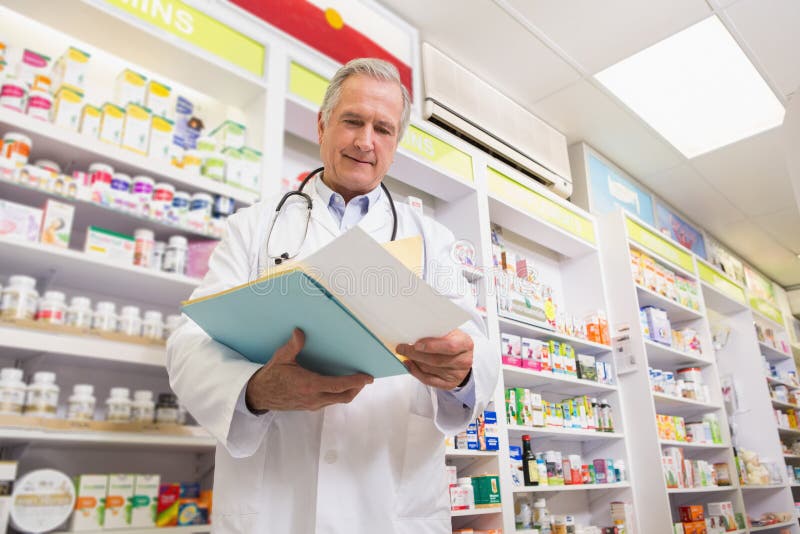 Smiling Doctor Reading a Prescription Stock Photo - Image of indoors ...