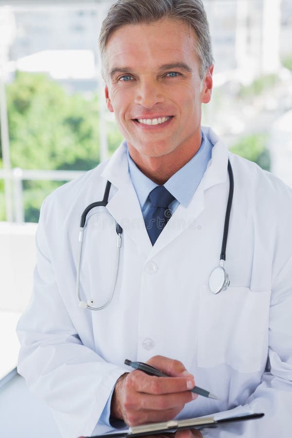 Smiling Doctor Standing with a Clipboard Stock Image - Image of medical ...