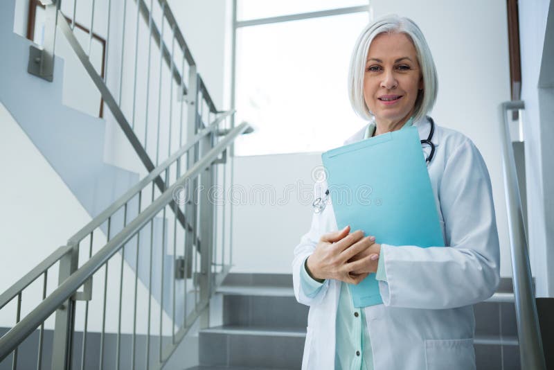 Smiling Doctor Standing with File in Hospital Stock Image - Image of ...