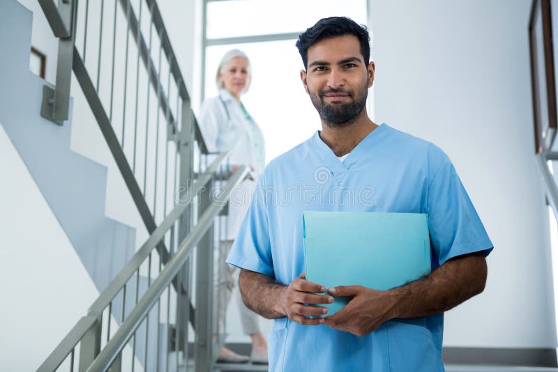 Smiling Doctor Standing with File in Hospital Stock Image - Image of ...
