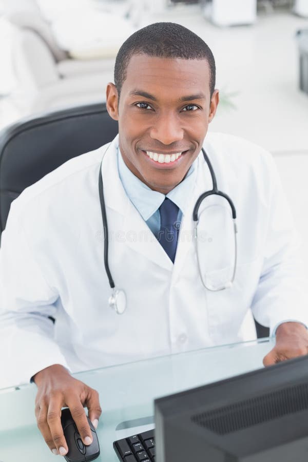 Smiling Doctor Using Computer at Medical Office Stock Image - Image of ...