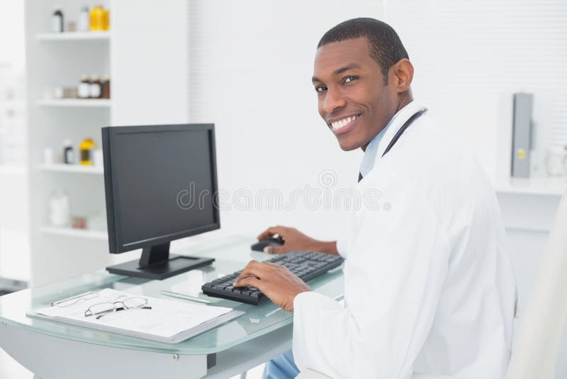 Smiling Doctor Using Computer at Medical Office Stock Image - Image of ...