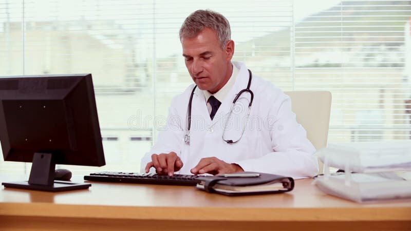 Smiling Doctor Using His Computer Stock Footage - Video of sitting ...