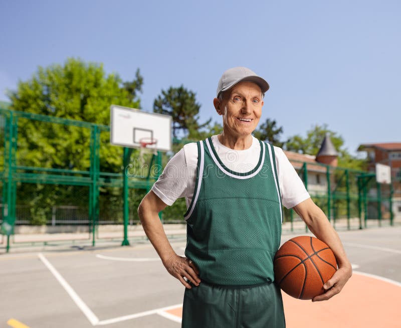 Smiling Elderly Man Holding a Basketball on a Basketball Court Stock ... Smiling Elderly Man Holding a Basketball on a Basketball Court Stock ...