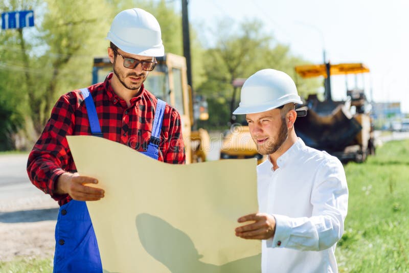 Smiling Engineer with Helmet Standing in Front of Excavator on Road ...