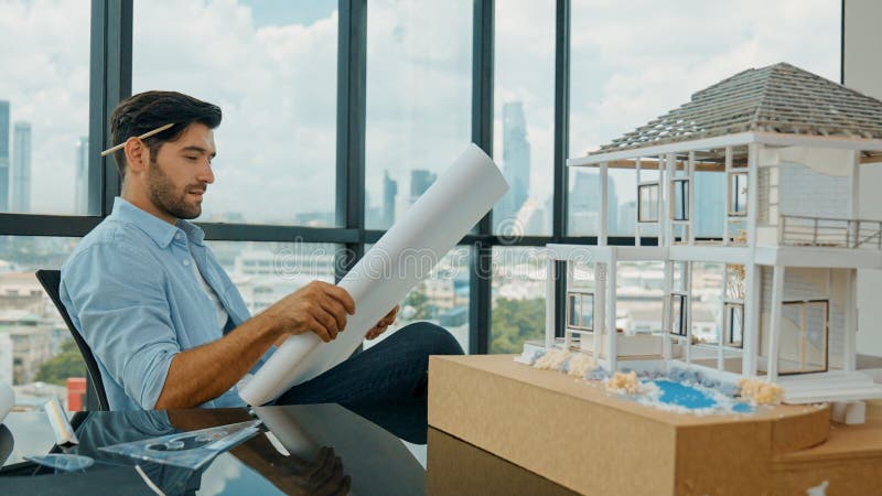 Smiling Engineer Looking Project Plan while Design House Model. Tracery ...