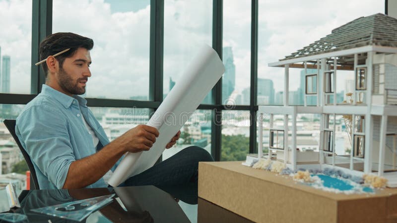 Smiling Engineer Looking Project Plan while Design House Model. Tracery ...