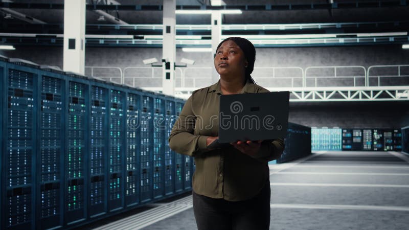 Smiling Engineer Walking in Data Center with Laptop, Checking Hardware ...