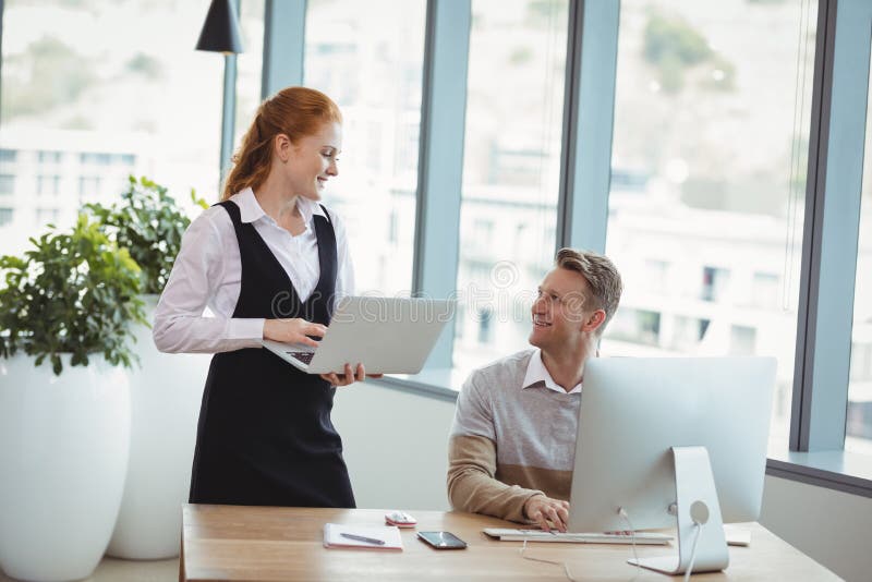 Smiling Executives Interacting while Working at Desk Stock Image ...