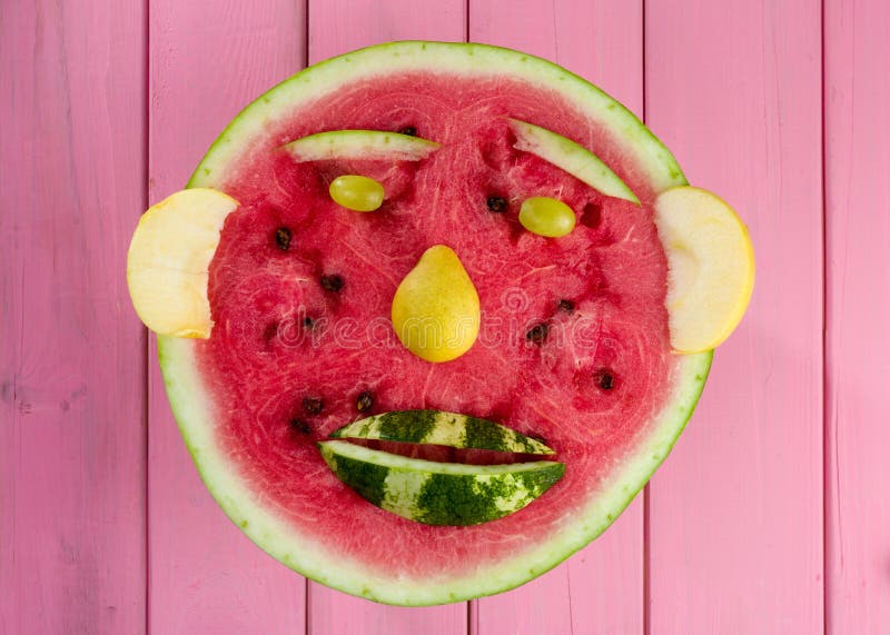 A Smiling Face from a Cut Watermelon and Various Fruits. on a Pink ...